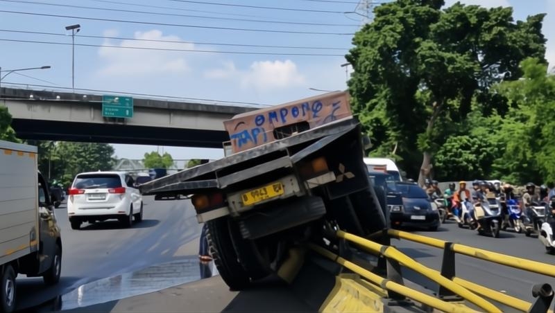 Brak! Truk Oleng Tabrak Pembatas Jalan hingga Nyangkut di Grogol Jakbar